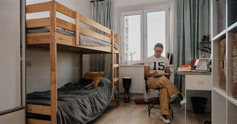 이층 침대 앞 의자에 앉아 있는 남자 사진 Unsplash의 기숙사 방 이미지