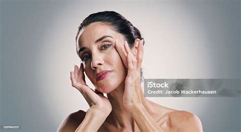 자연스러운 스킨 케어 초상화 및 노화 방지를위한 콜라겐 트리트먼트의 빛 터치 및 결과가있는 여성 성숙한 모델 자신감 있는 얼굴과 화장품 피부과와 아름다움이 회색 스튜디오