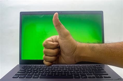 흰색 배경에 고립된 녹색 화면이 있는 노트북 앞에서 엄지손가락을 치켜드는 손 승인 긍정성 또는 기술 개념에 적합 긍정적인 감정 표현에 대한 스톡 사진 및 기타 이미지