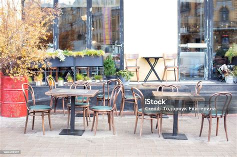 테이블과 나무 의자가 있는 테라스가 있는 빈 카페 레스토랑의 거리 빈티지 외관 유럽의 거리에 있는 커피숍용 가구 카페 테이블이