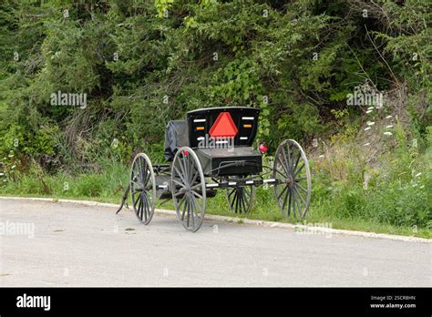 Amish Buggy Hack With A Caution Sign Parked On The Side Of The Road
