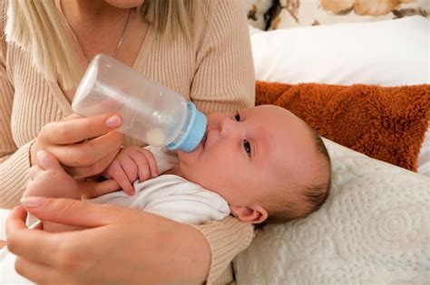 Mamá Alimenta A Un Bebé Recién Nacido Con Un Biberón El Sol Brilla En