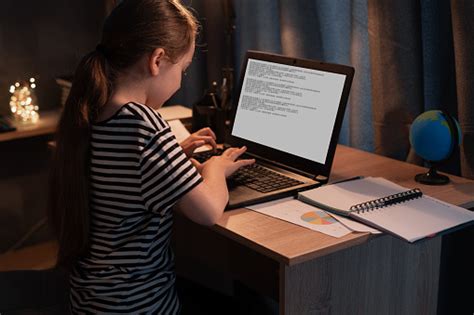 밤에 집에서 노트북 컴퓨터를 가진 어린 학생 소녀 Pc 화면을보고 키보드에 타이핑하는 행복한 학생 웨비나 온라인 코스 어린이