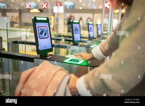 crop woman using smartphone while scanning info into smart gate pass in