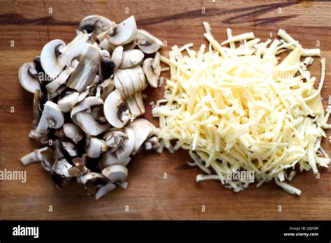 Freshly Grated Yellow Cheese And Chopped Button Mushrooms On A Rustic