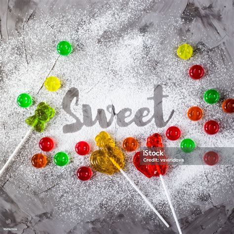 단어 달콤한 다 색된 과자 및 Cockerels의 형태로 복고 사탕 가루 설탕의 도움으로 회색 콘크리트 백그라운드에 기록 됩니다 평면도 평면 위치 0명에 대한 스톡 사진 및