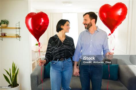 손과 하트 모양의 풍선을 잡고 집에서 편안하게 발렌타인 데이를 축하하는 다정한 커플 2명에 대한 스톡 사진 및 기타 이미지 2명 거실 남자 Istock