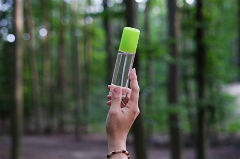 녹색 자연 배경에 화장품 바디 스프레이를 들고 있는 여자 손 유기농 향수가 든 유리병 건강관리와 의술에 대한 스톡 사진 및 기타