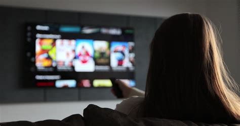 Premium Photo Woman Selects Tv Channels With Remote Control At Living Room On Sofa Woman