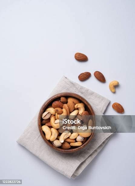 견과류 아몬드 피스타치오 캐슈는 연한 파란색 배경의 린넨 냅킨에 나무 그릇에 놓습니다 견과에 대한 스톡 사진 및 기타 이미지 견과 캐슈 보울 Istock