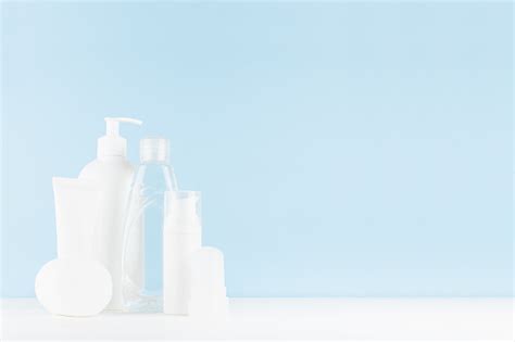 흰색 빈 화장품 병은 위생 클렌징 및 바디 케어 치료 복사 공간을 위해 테이블에 부드러운 하늘색 배경에 모형을 만듭니다 브랜딩 광고 디자인을 위한 화장품 제품 템플릿입니다