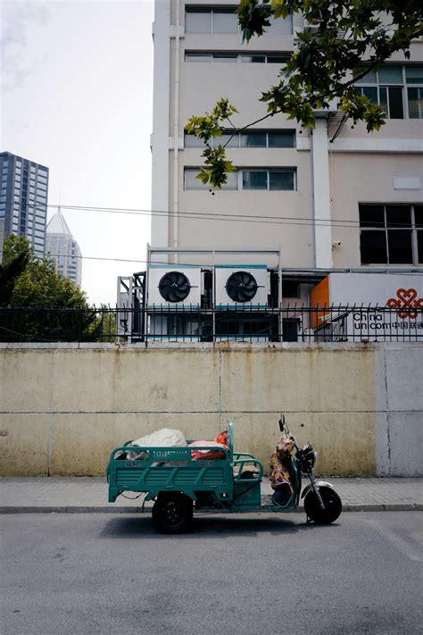 낮 동안 흰색 콘크리트 건물 옆에 주차 된 녹색 차 사진 Unsplash의 무료 회색 이미지