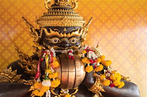 일식을 일으키는 악마 인 라후 태국에서는이 악마가 달을 먹고 달의 일식을 일으킨다고 믿어집니다 그는 구체를 먹고 손에 꽃을 들고 있습니다 악령 허구적 존재에 대한 스톡 사진