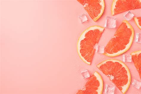 왼쪽에 카피 스페이스와 고립 된 파스텔 핑크 배경에 반 슬라이스 자몽 얼음 큐브와 물 방울의 상단 보기 사진 자몽에 대한 스톡 사진 및 기타 이미지 Istock