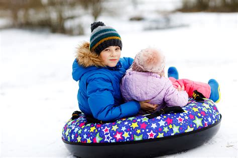 활동적인 유아 소녀와 학교 소년은 스노우 튜브에 언덕 아래로 함께 슬라이딩 행복한 아이들 썰매에 겨울에 야외에서 재미를 형제 형제 자매 튜브 눈 내리막 가족 시간 2명에