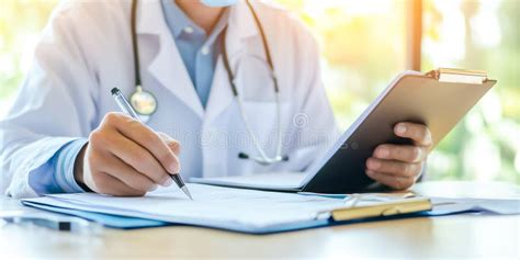 Icu Doctor Writes Case Notes To Document And Review Patients Progress