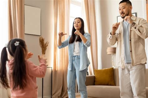 Padres E Hija Japoneses Haciendo Movimientos Divertidos Bailando En Casa Foto Premium