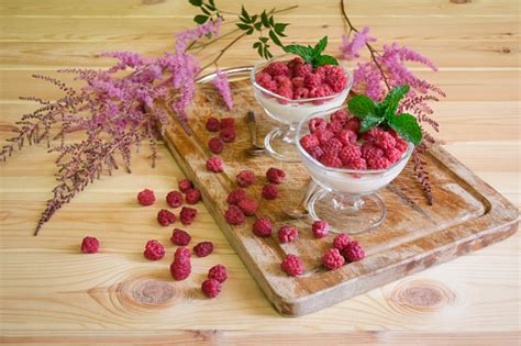 나무 테이블에 아이스크림 유리 그릇에 신선한 라즈베리와 판나 코타 근처 아스틸베 꽃과 신선한 라즈베리 선택적 초점 0명에 대한 스톡 사진 및 기타 이미지 Istock