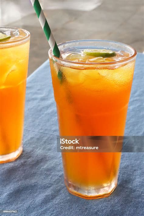 해변 레스토랑 바 장면 두 개의 감귤류 오렌지 목테일 녹색과 흰색 종이 마시는 빨대 얼음 조각과 파란색 식탁보가 있는 테이블에