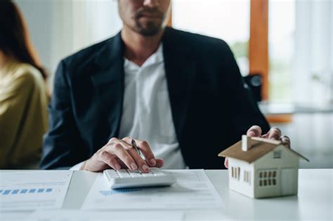 모기지 부서의 은행 직원은 서류 작업을 진행하고 고객이 투자 잠재력을 평가할 수 있도록 대출 금리 계산기를 사용하고 있습니다 개념에 대한 스톡 사진 및 기타 이미지 Istock