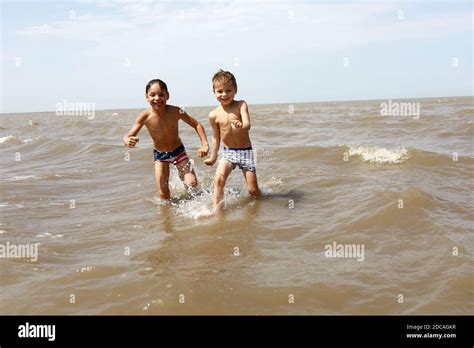 Happy boys running in the Sea of ??Azov Stock Photo - Alamy