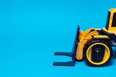 파란색 배경에 노란색 검은 색 지게차 장난감 타자기 장난감 가게 텍스트카피 스페이스 장소 용 어린이를위한 건설 장비 트랙터 완구류에 대한 스톡 사진 및 기타 이미지 Istock