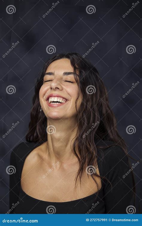 Portrait On Dark Background Of Young Turkish Girl Bursting Out Laughing With Closed Eyes Stock