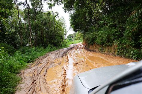 태국 북부의 열대 우림에서 진흙 투성이의 젖은 시골 도로에 4 륜 자동차 트럭 트랙 트레일 진흙 도로 숲 자연 시골 풍경 갈색 점토 웅덩이 도로 국가의 운송 0명에 대한
