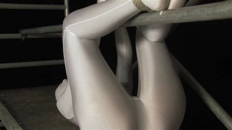 Encased Girl In Shiny Zentai Suit Is Tied To A Metal Pole And Tries To Escape