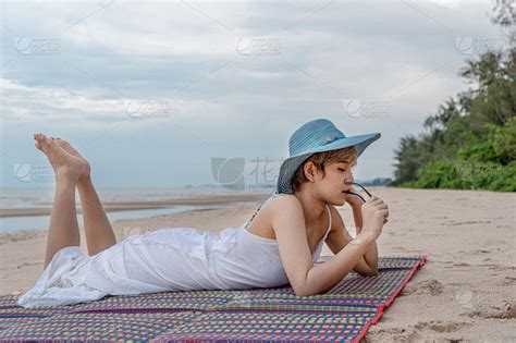 美丽的女模特享受在海滩上放松