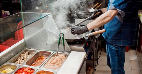 백인 수석 요리사는 아시아 레스토랑 주방에서 냄비 팬으로 요리합니다 사진 Unsplash의 상업용 주방 이미지