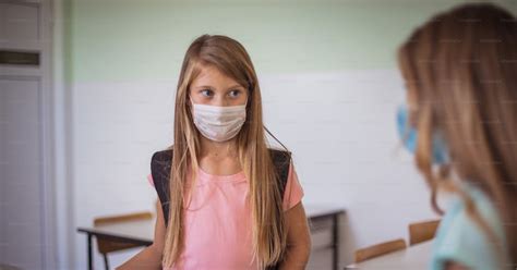 바이러스 기간 동안 학교에서의 사회적 거리 교실에서 두 명의 학교 아이들이 이야기하고 있습니다 안면 마스크로 사진 Unsplash의 세르비아 이미지