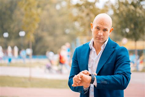 작업 일정을 계획 하는 손목 시계를 보고 정식 소송에서 심각한 남성 기업가 자신감 행정 매니저 회의 야외에 서 서 기다리는 동안 시간을 확인 개인 장식품에 대한 스톡 사진