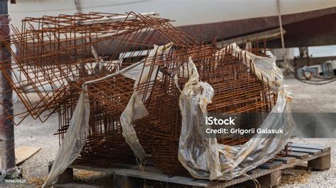 건설 현장의 배경에 투명한 필름으로 싸여있는 땅에 누워있는 녹슨 철근 더미의 클로즈업 0명에 대한 스톡 사진 및 기타 이미지 0명 Charitable