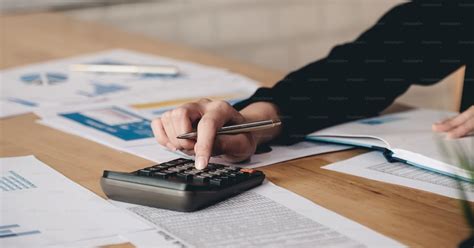 사무실 및 비즈니스 작업 배경 세금 회계 통계 및 분석 연구 개념에서 나무 책상에 수학 금융을 수행하기 위해 계산기를