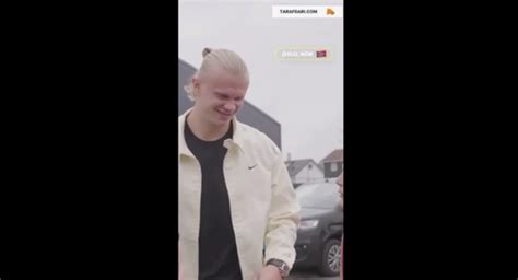 ارلینگ هالند لوگو باشگاه منچستریونایتد را در هنگام عکس گرفتن با کودک