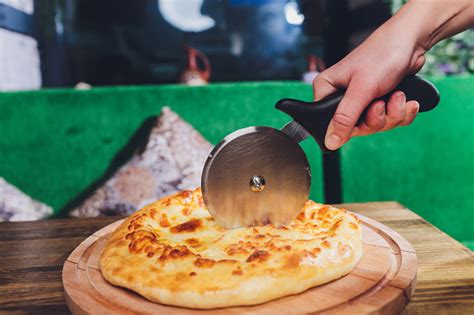 테이블에 나무 보드에 고추와 올리브와 햄 피자를 슬라이스 피자 커터 휠 건강한 식생활에 대한 스톡 사진 및 기타 이미지 건강한 식생활 과일 남자 Istock