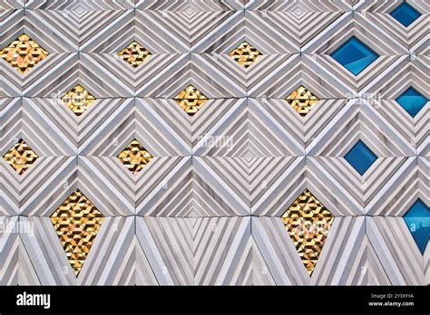 A Modern Architectural Wall Featuring A Geometric Pattern Of Alternating Gold And Blue Shapes