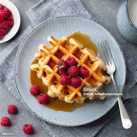 메이플 시럽과 신선한 라즈베리를 곁들인 벨기에 와플 회색 배경입니다 맨 위 보기 0명에 대한 스톡 사진 및 기타 이미지 0명