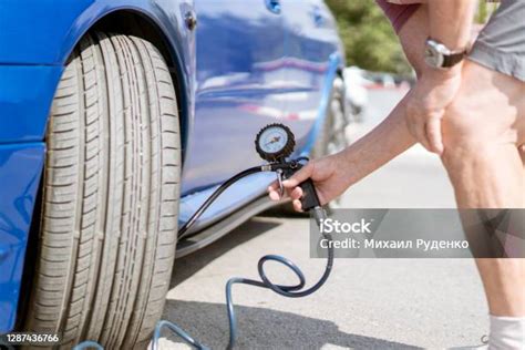 사람이 기마계가있는 압축기로 자동차 바퀴 타이어를 펌프합니다 타이어에 대한 스톡 사진 및 기타 이미지 타이어 피곤한 바람