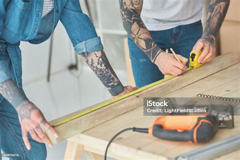 나무 판자를 사용 하 고 테이프를 측정 하는 문신 부부의 자른된 샷 가정의 방에 대한 스톡 사진 및 기타 이미지 가정의 방 개선 남자 Istock