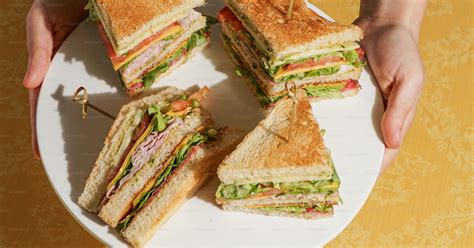 샌드위치가 반으로 자른 접시를 들고 있는 사람 사진 Unsplash의 군침 도는 이미지