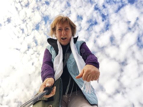A Happy Funny Funny Adult Girl Takes A Selfie Against A Blue Sky With
