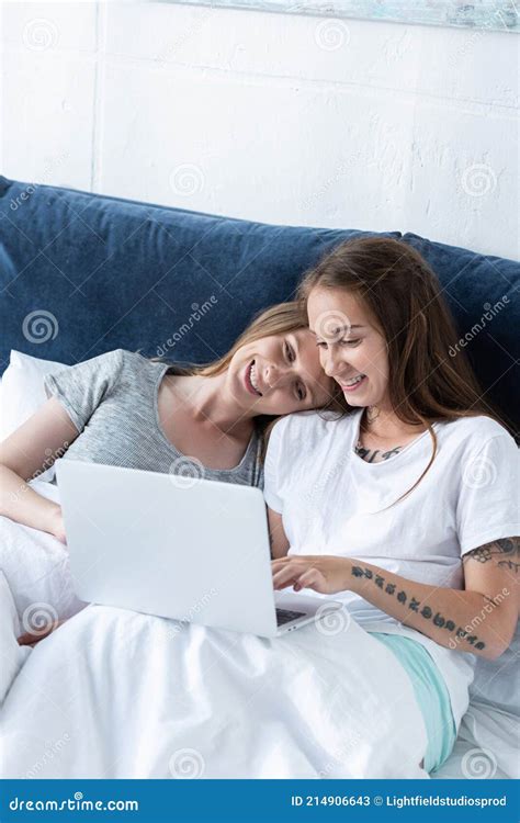 Two Smiling Lesbians Embracing While Using Laptop In Bed In Morning Stock Image Image Of