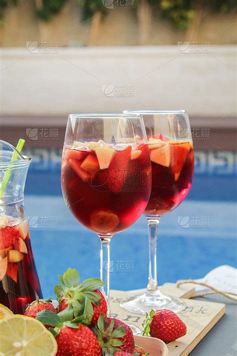 西班牙水果红酒桑格利亚汽酒。草莓、橘子、苹果和香蕉片。在游泳池旁边的托盘上