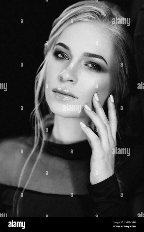 Blonde Girl With Blue Eyes In A Black Dress In A Dark Turquoise