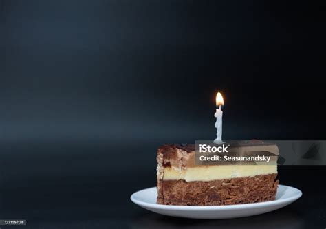 깊은 검은 색 배경에 흰색 접시에 하나의 불타는 촛불 초콜릿 생일 케이크 조각 생일 파티 축하 기념일 텍스트를 복사하여 닫습니다 0명에 대한 스톡 사진 및 기타 이미지
