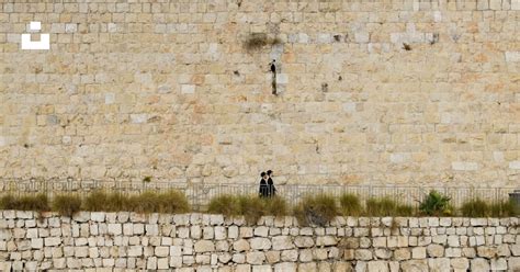 베이지색 벽돌 벽 옆을 걷는 두 사람 사진 Unsplash의 무료 이스라엘 이미지