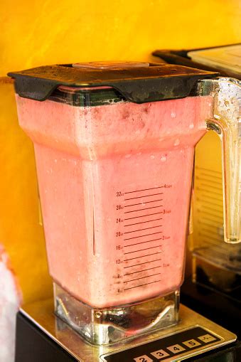 전문 현대 전기 믹서 기 근접 촬영에서에서 야채와 과일 스무디 건강 한 스무디를 만들기 위한 믹서 기를 사용 하 여 작업자는 신선한 커트 과일을 가진 고속 믹서에 전환