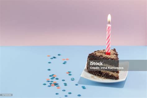 파란색 배경에 촛불과 색종이가있는 생일 케이크 조각 불타는 촛불이있는 흰색 접시에 초콜릿 케이크 조각 생일의 개념 0명에 대한 스톡 사진 및 기타 이미지 Istock